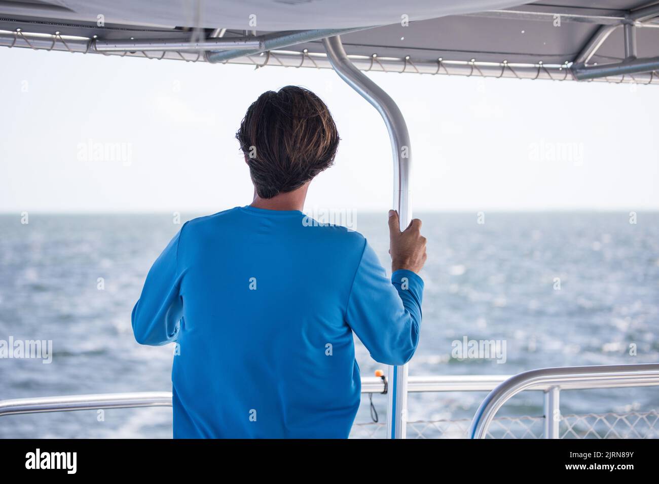 A back view of a boy looking at the sea from the boat Stock Photo - Alamy