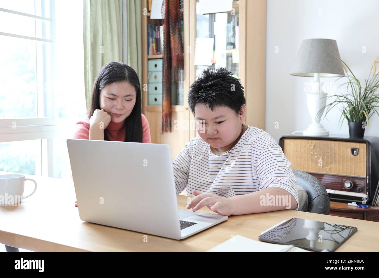 The Asian single mom helping her son to learn from home Stock Photo - Alamy
