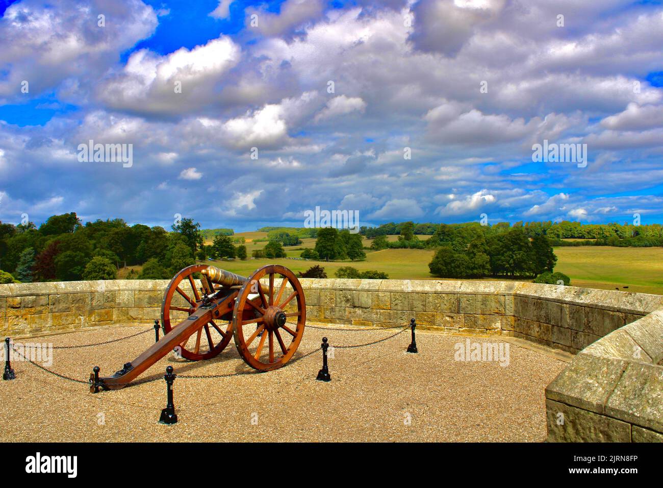 A cannon wheel placed in an outdoor museum with trees and clouds in the ...
