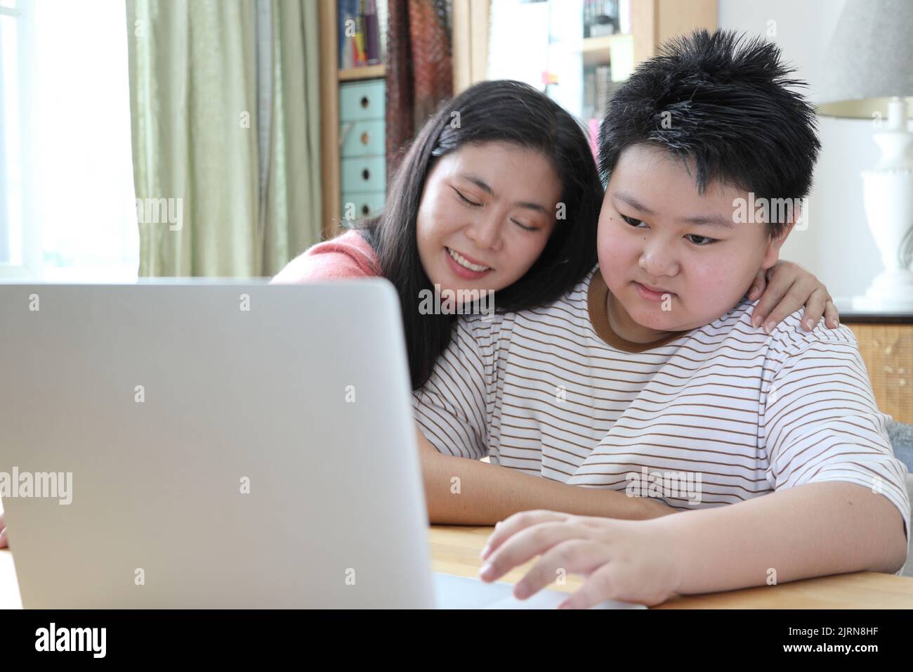 The Asian single mom helping her son to learn from home Stock Photo - Alamy