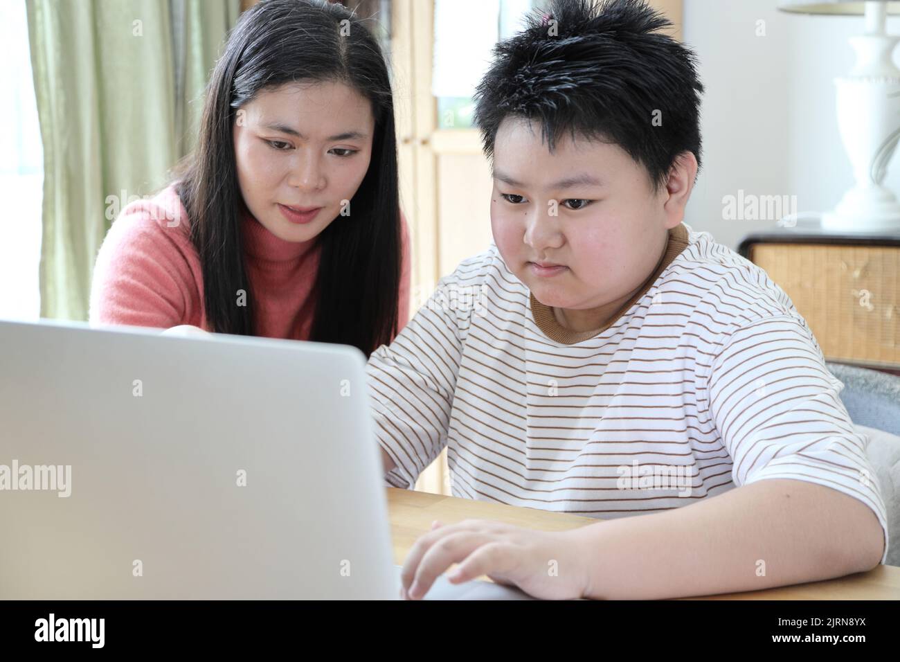 The Asian single mom helping her son to learn from home Stock Photo - Alamy