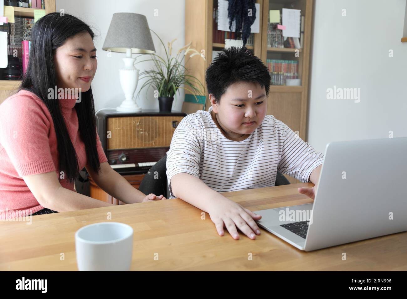 The Asian single mom helping her son to learn from home Stock Photo - Alamy