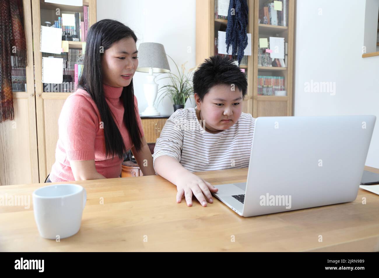 The Asian single mom helping her son to learn from home Stock Photo - Alamy