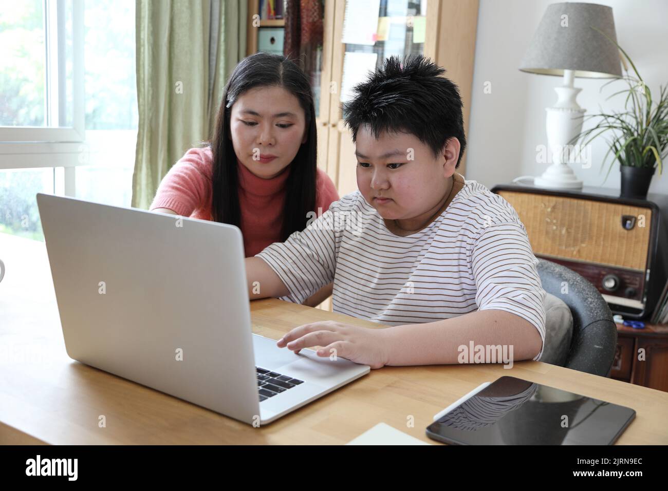 The Asian single mom helping her son to learn from home Stock Photo - Alamy