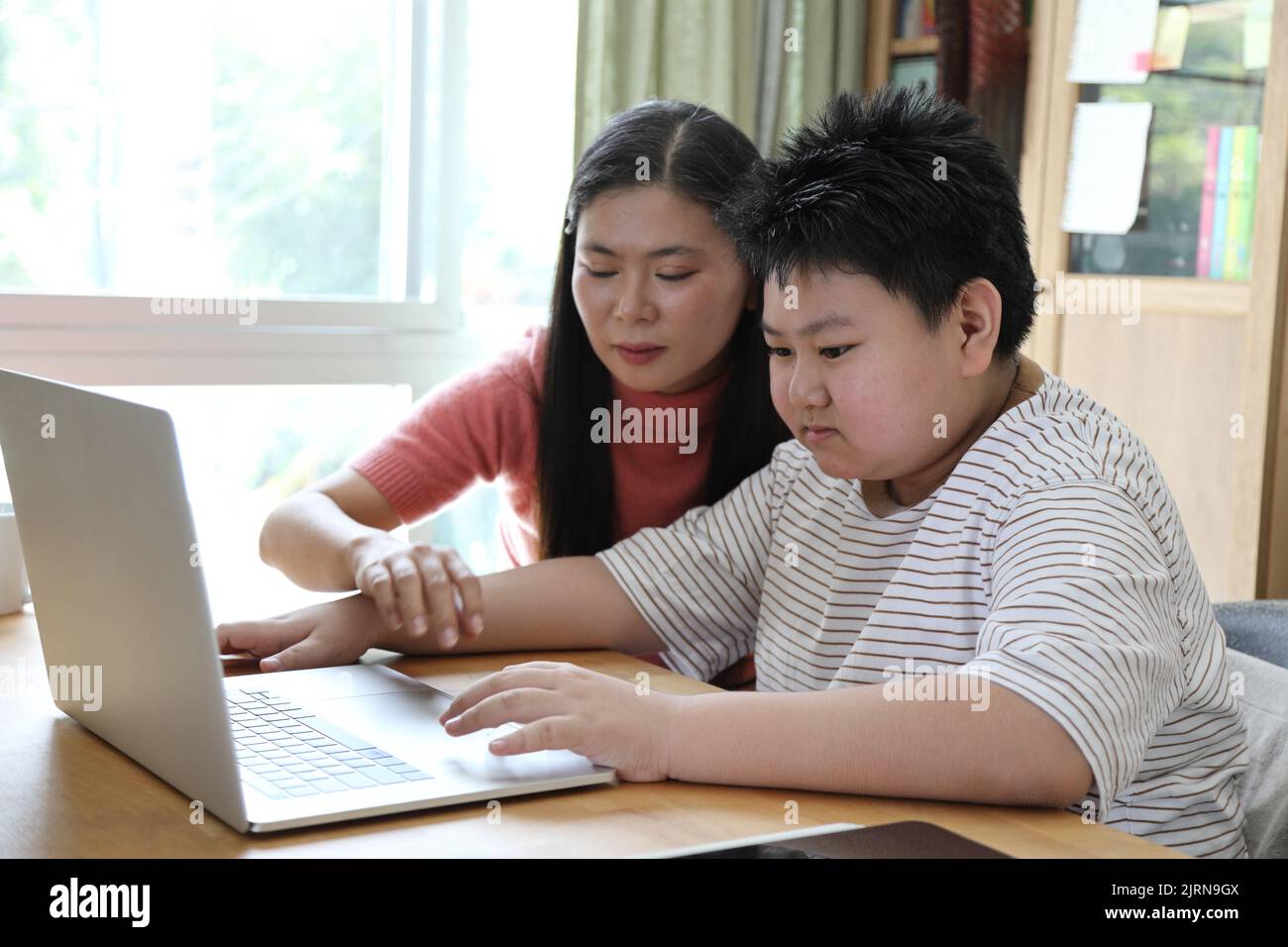 The Asian single mom helping her son to learn from home Stock Photo - Alamy