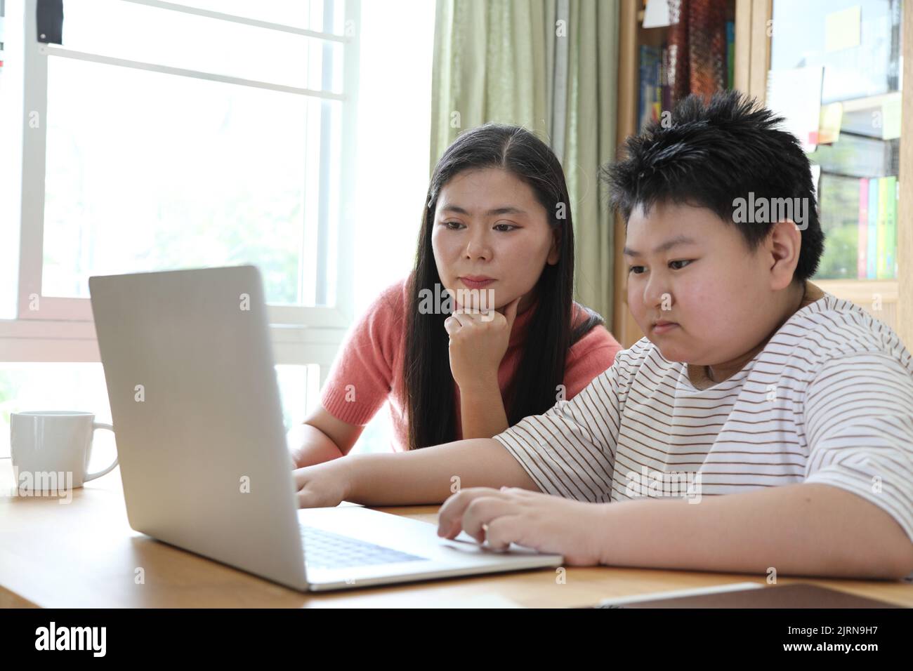 The Asian single mom helping her son to learn from home Stock Photo - Alamy