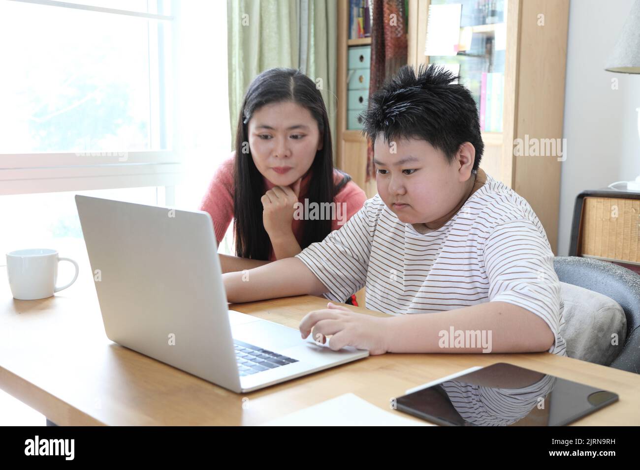 The Asian single mom helping her son to learn from home Stock Photo - Alamy