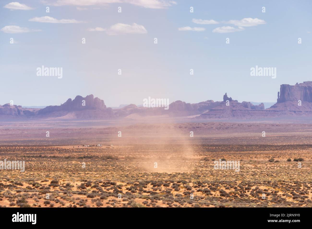 Dust Devil on a hot sunny day in a desert with red rocky mountains in ...