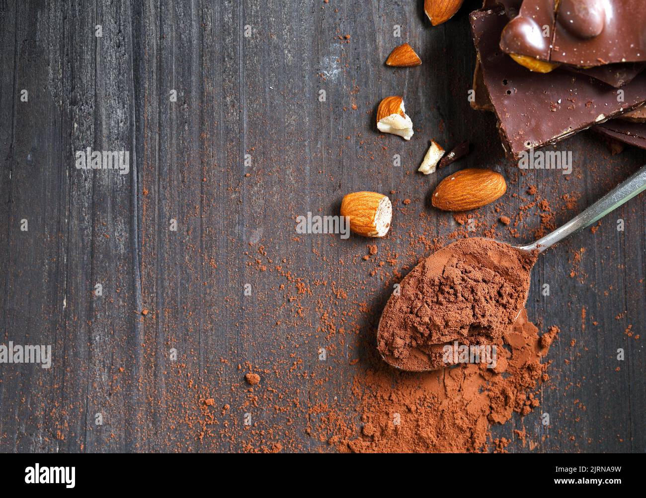 Cocoa Powder and Dark Chocolate almond on black wood table Stock Photo ...
