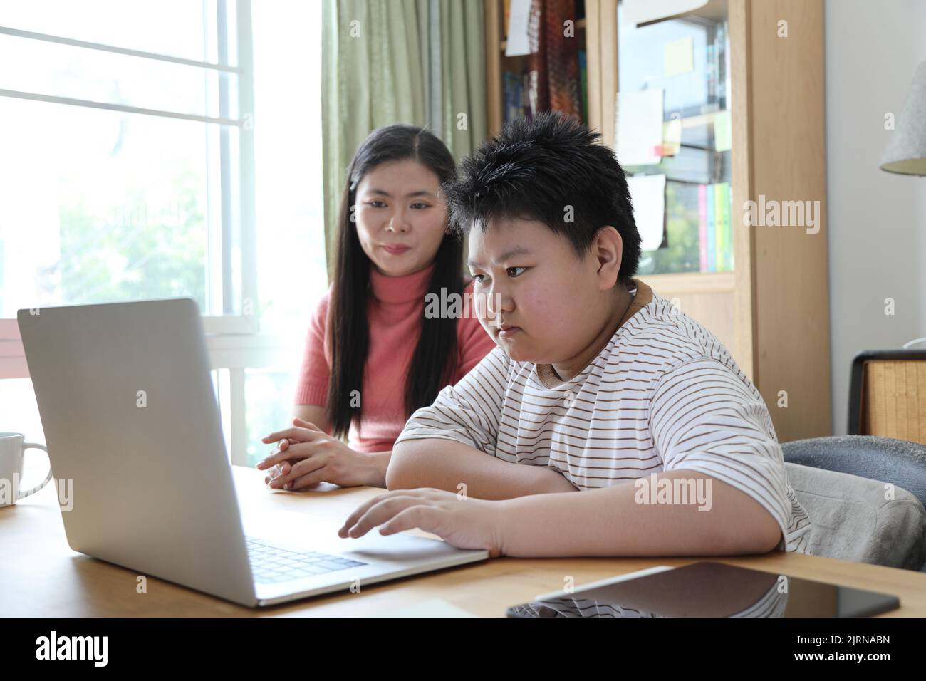 The Asian single mom helping her son to learn from home Stock Photo - Alamy