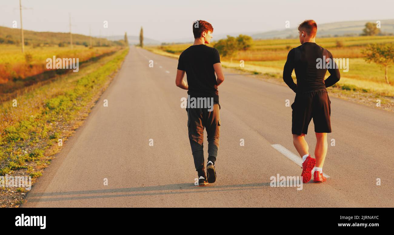The two sportsmen running on the street on the sunny background Stock ...