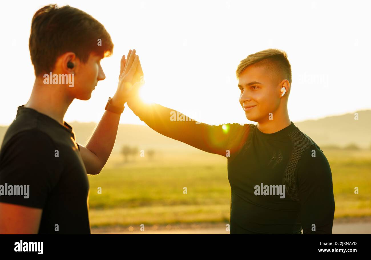 Two athletes clap their hands after finishing the exercises, they are ...