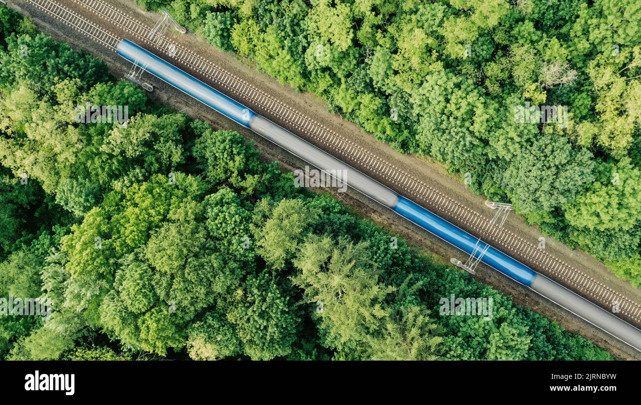 An aerial view of a train driving through green forest Stock Photo - Alamy