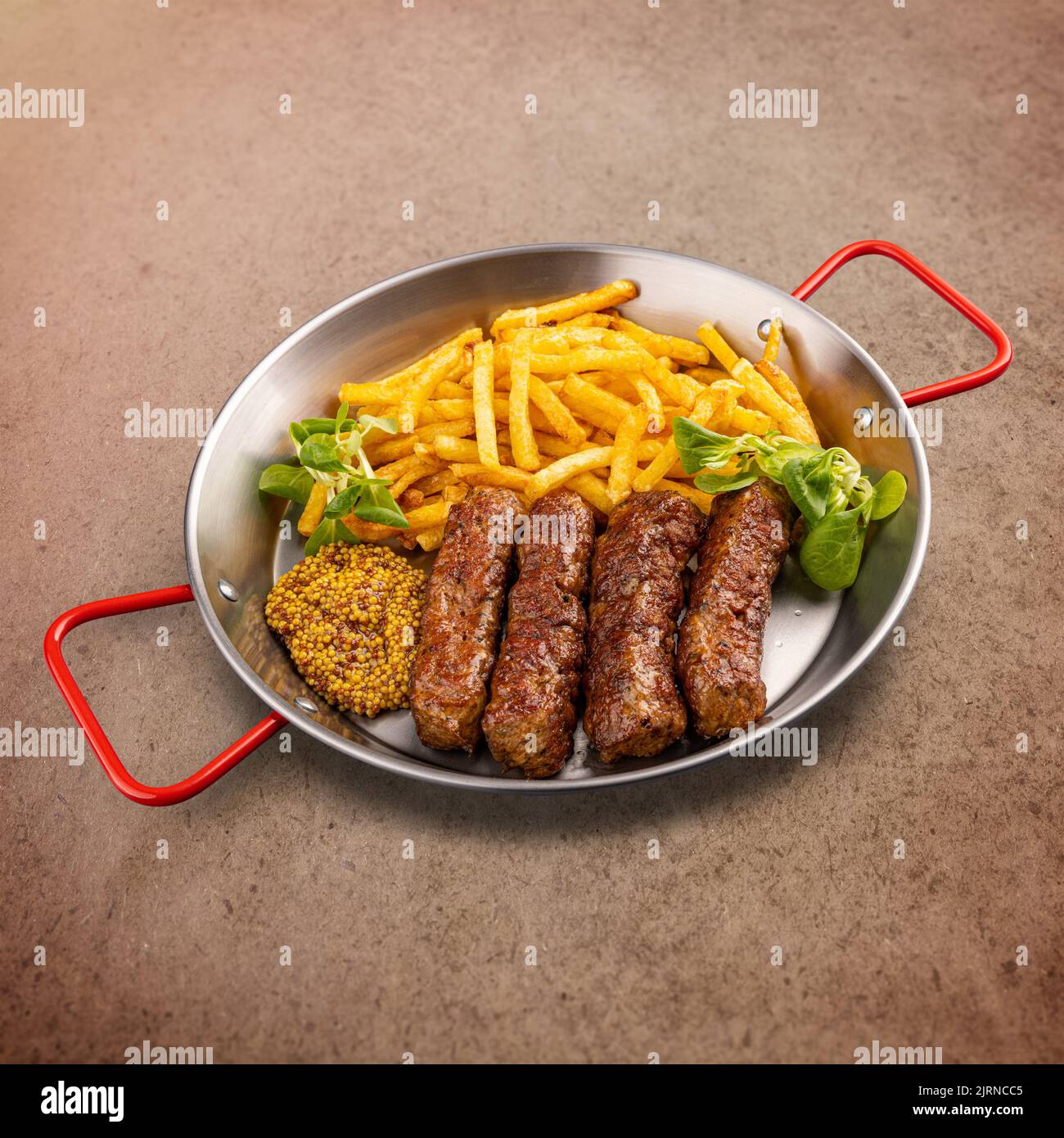 Grilled Romanian meat rolls called mititei or mici served with fries ...