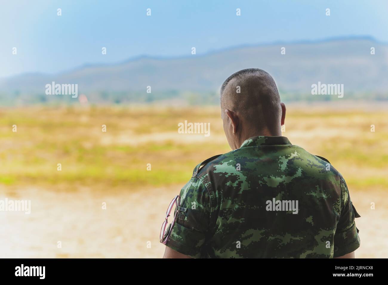 Back view of Asian army soldier stands to explore the landscape in ...