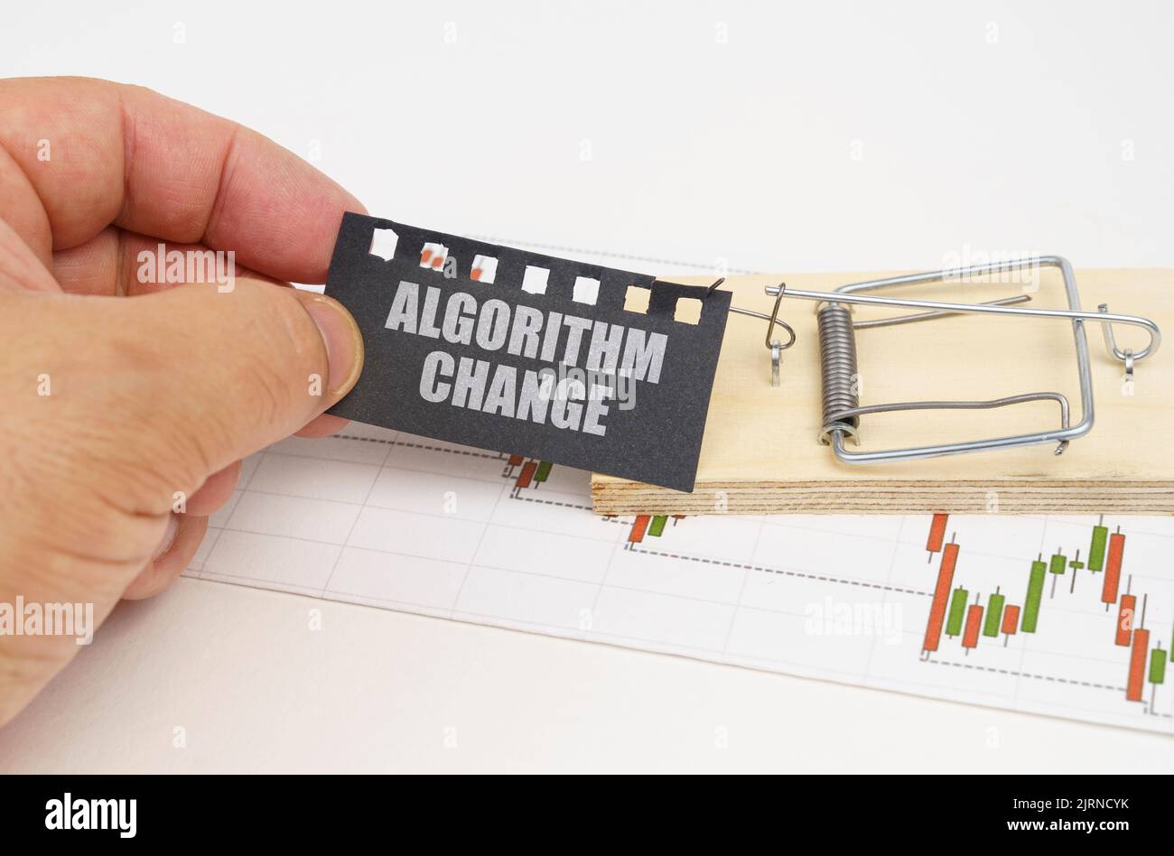 Business concept. On the quote chart there is a mousetrap from which the hand takes out a black ...