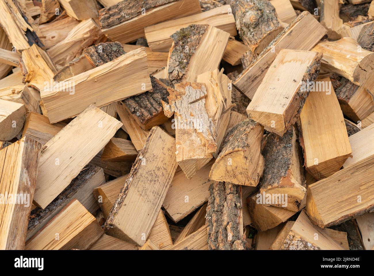 Dry sawn and chopped firewood in a pile under the open sky. Creative ...