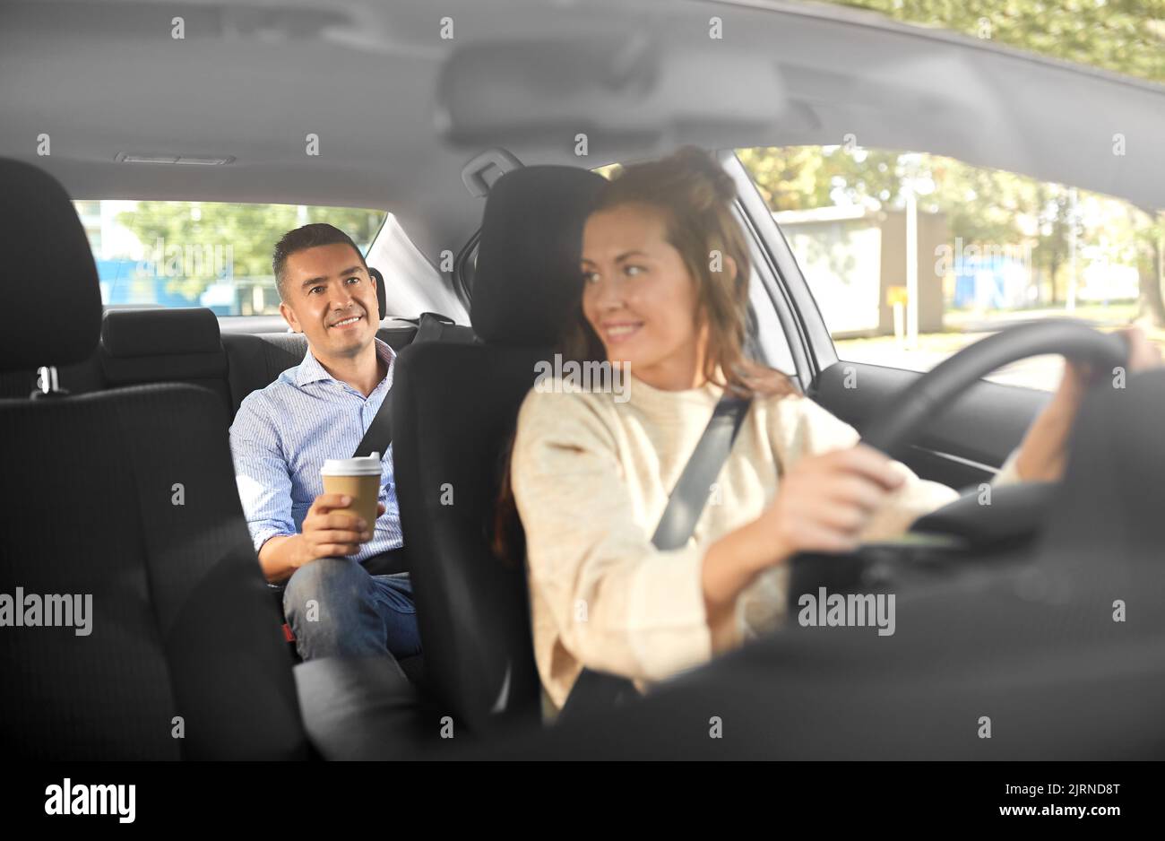 female driver driving car with male passenger Stock Photo - Alamy