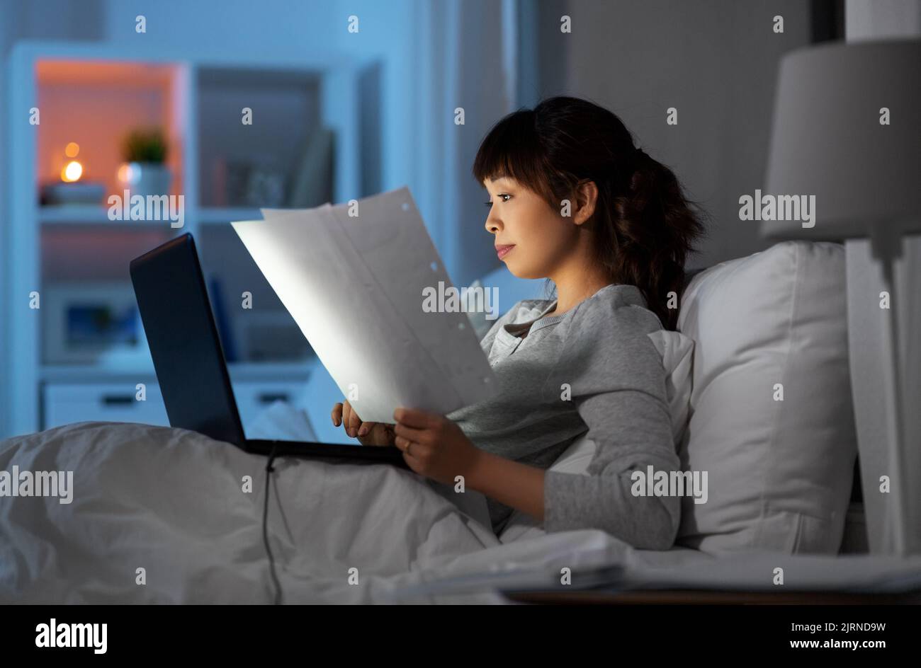 woman with laptop working in bed at night Stock Photo - Alamy