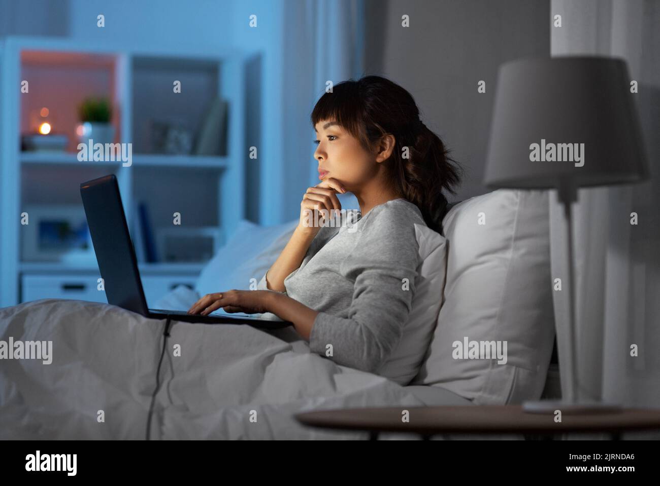 woman with laptop in bed at home at night Stock Photo - Alamy