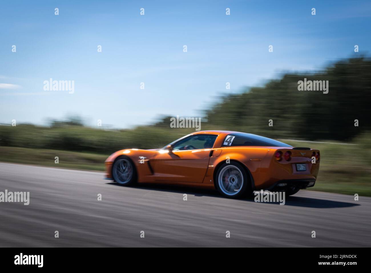 An orange race car chevrolet at the track Stock Photo - Alamy
