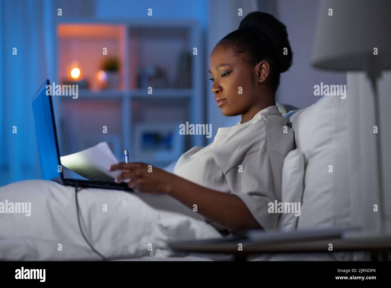 woman with laptop working in bed at night Stock Photo - Alamy