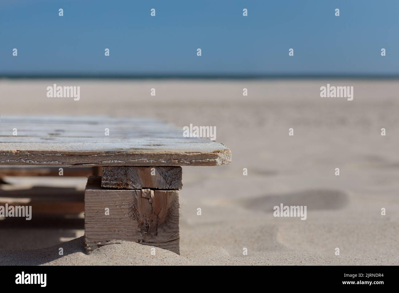 Wooden plank pallet on the beach on a sunny day. Shot from the front ...