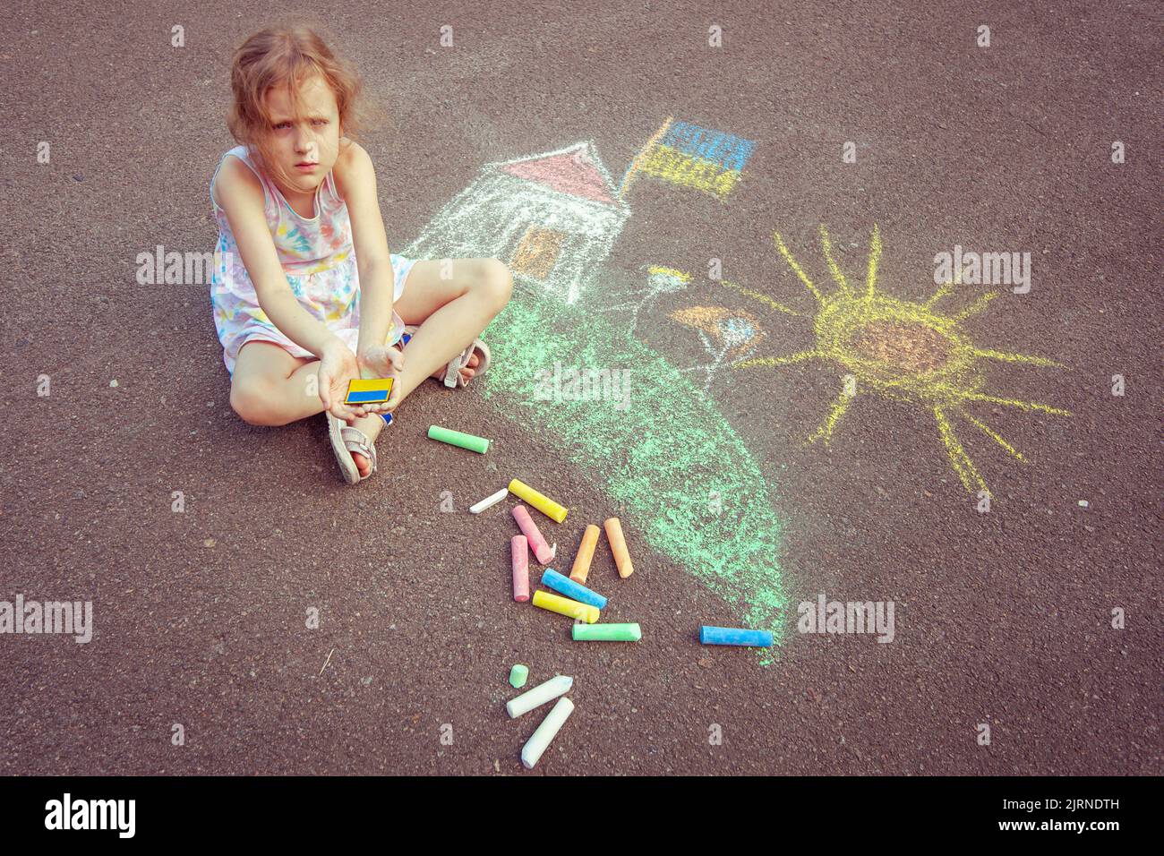 Ukrainian girl child draws children's drawings with chalk on the pavement Stock Photo - Alamy