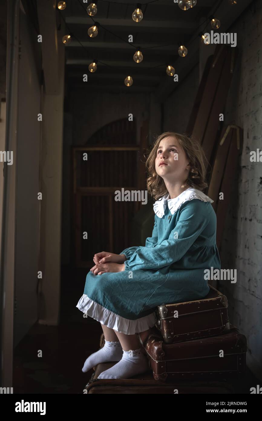 a little girl sits alone in a dark hallway. fear, loneliness Stock ...