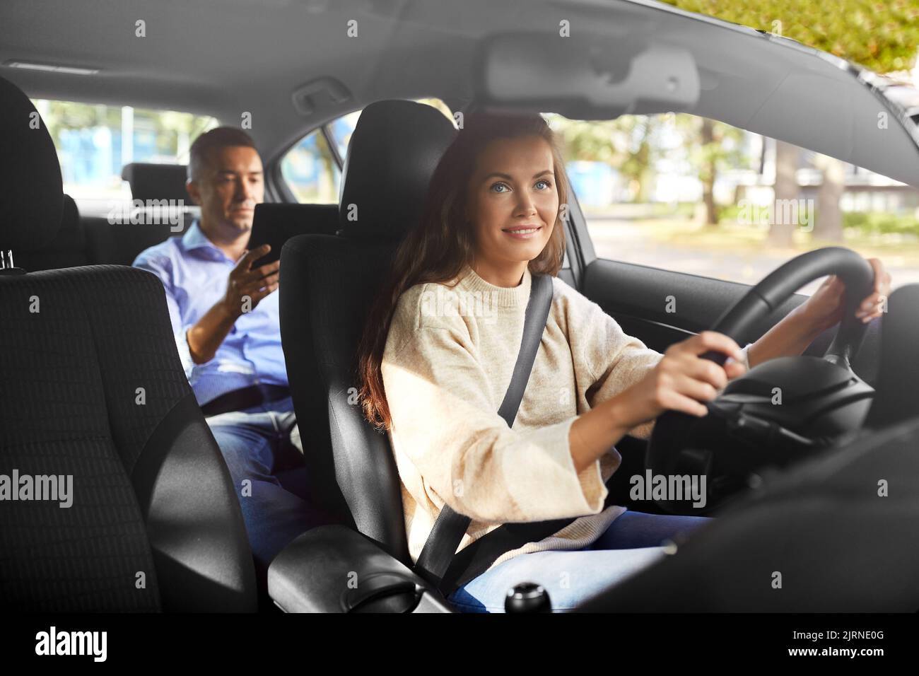 female driver driving car with male passenger Stock Photo - Alamy
