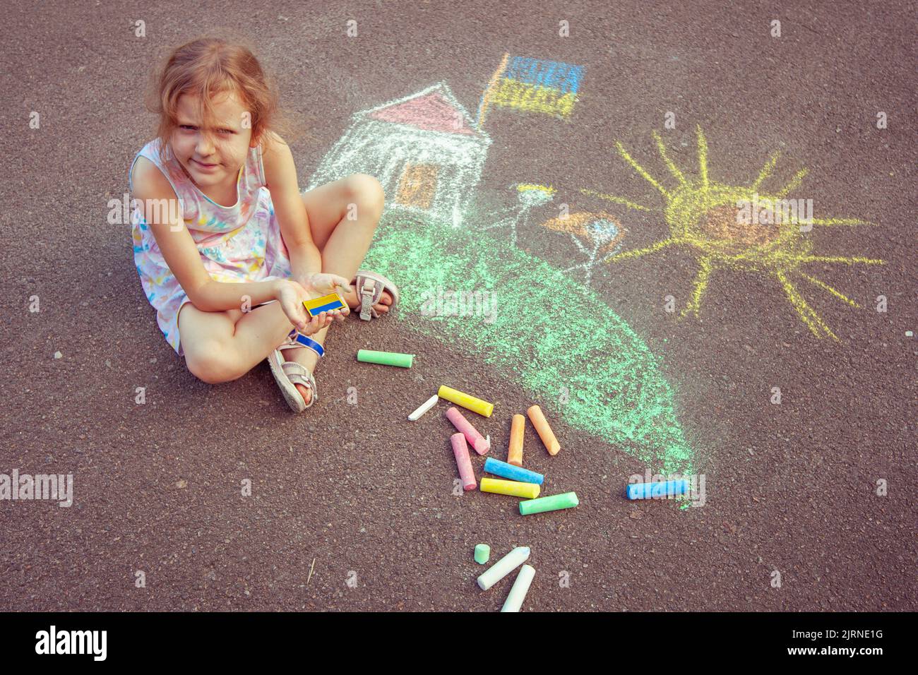 Ukrainian girl child draws children's drawings with chalk on the pavement Stock Photo - Alamy
