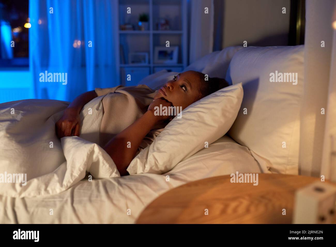 sleepless african woman lying in bed at night Stock Photo - Alamy