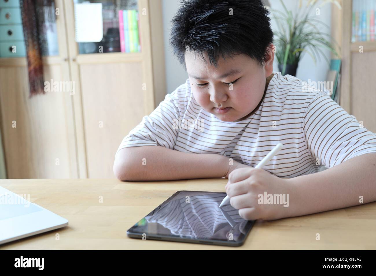 The Asian boy drawing picture on the tablet Stock Photo - Alamy