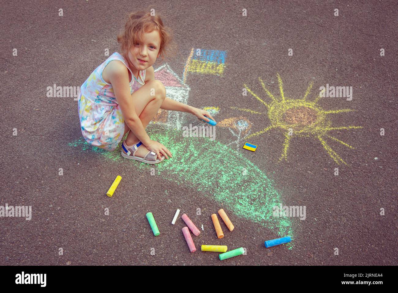 Ukrainian girl child draws children's drawings with chalk on the pavement Stock Photo - Alamy