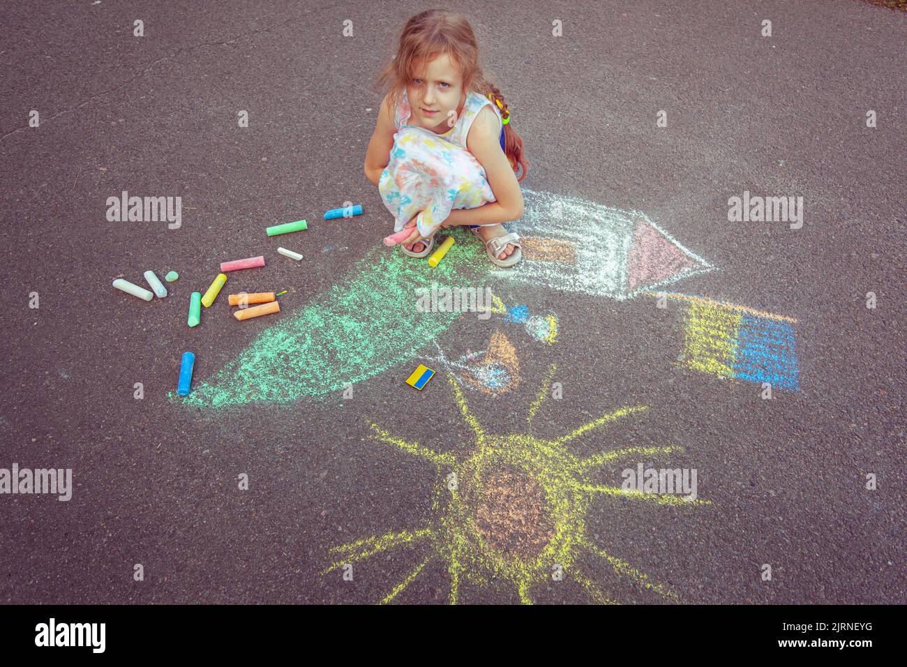Ukrainian girl child draws children's drawings with chalk on the pavement Stock Photo - Alamy