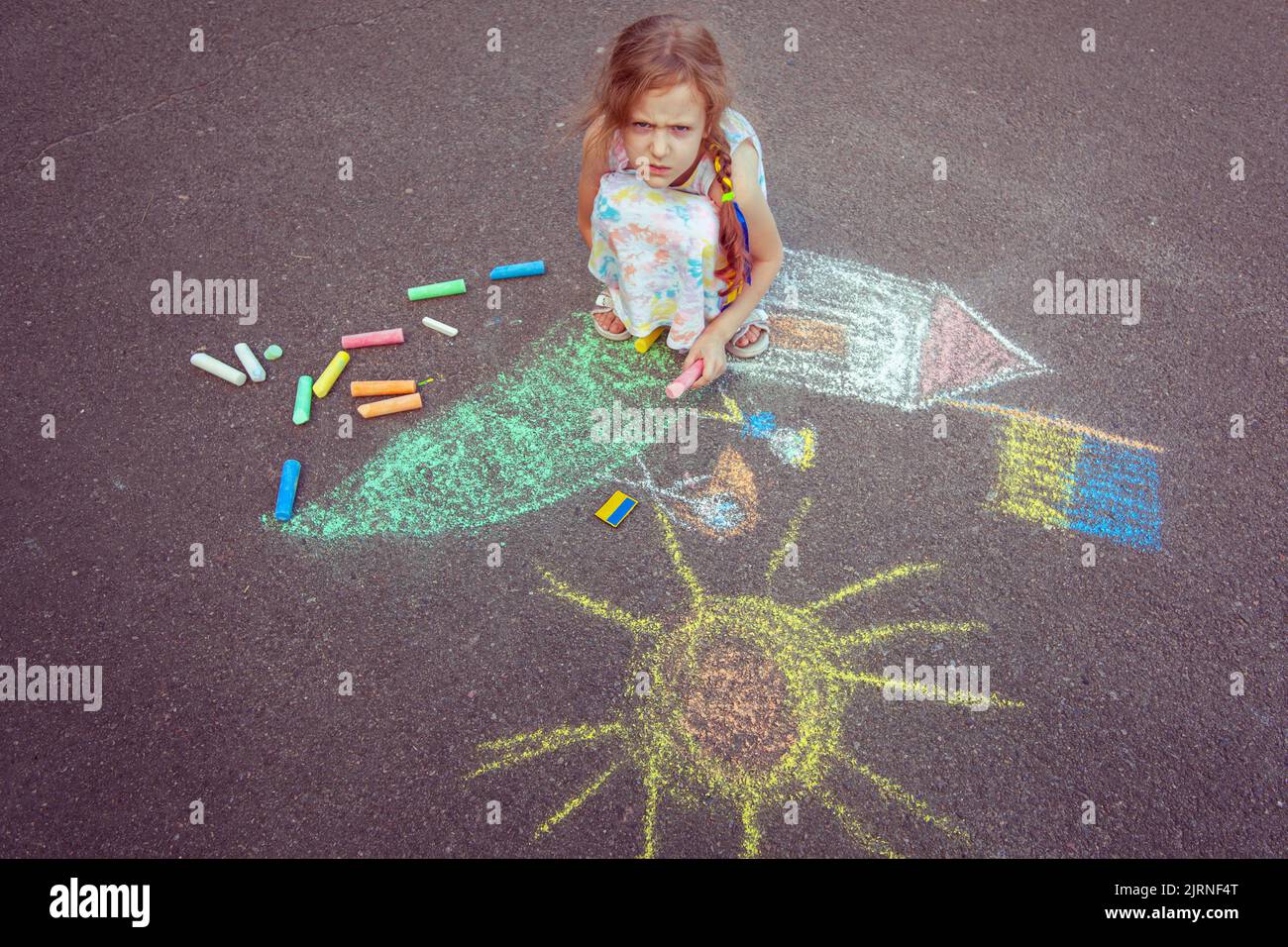 Ukrainian girl child draws children's drawings with chalk on the ...