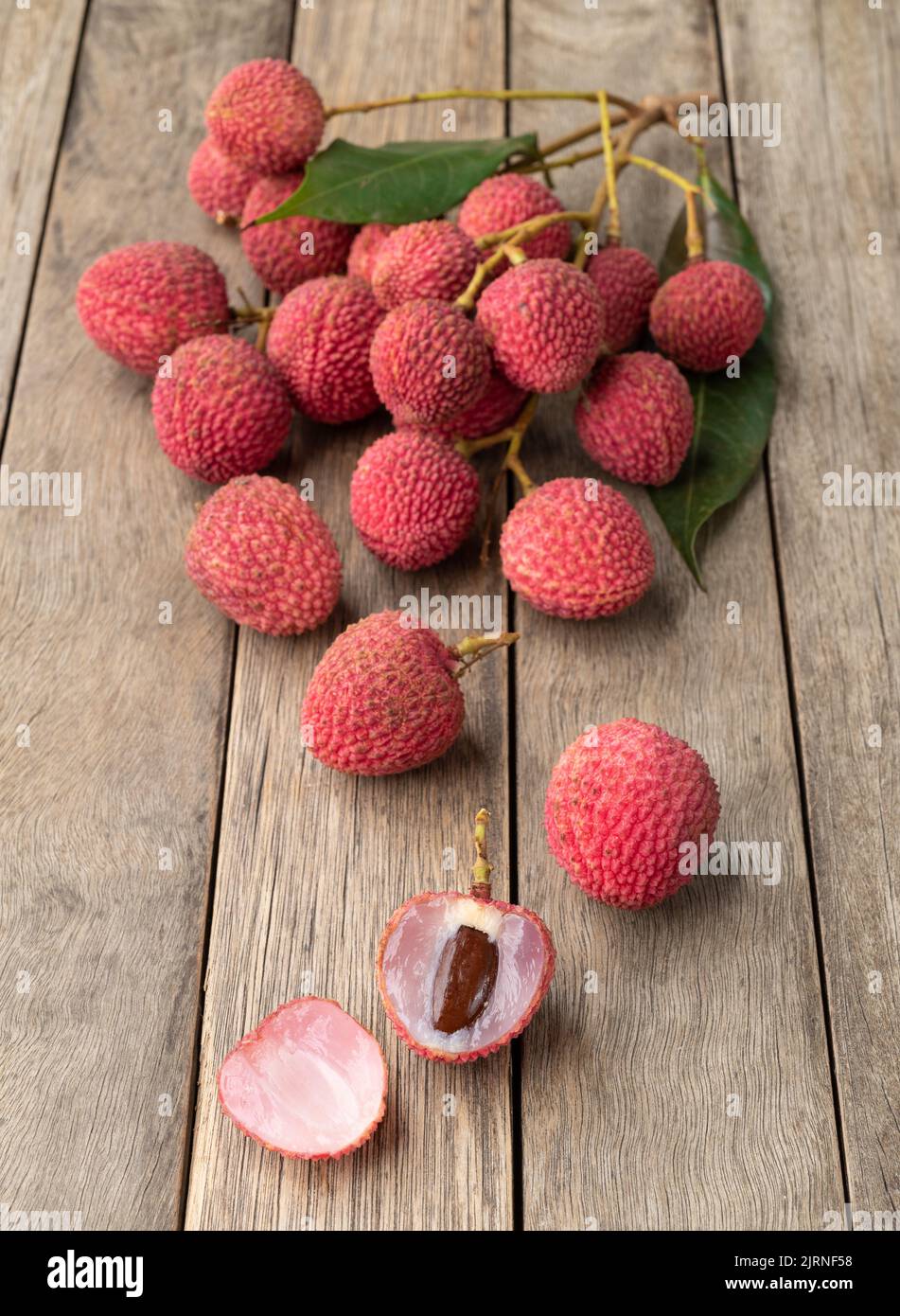 Lychees cut fruit over wooden table Stock Photo - Alamy