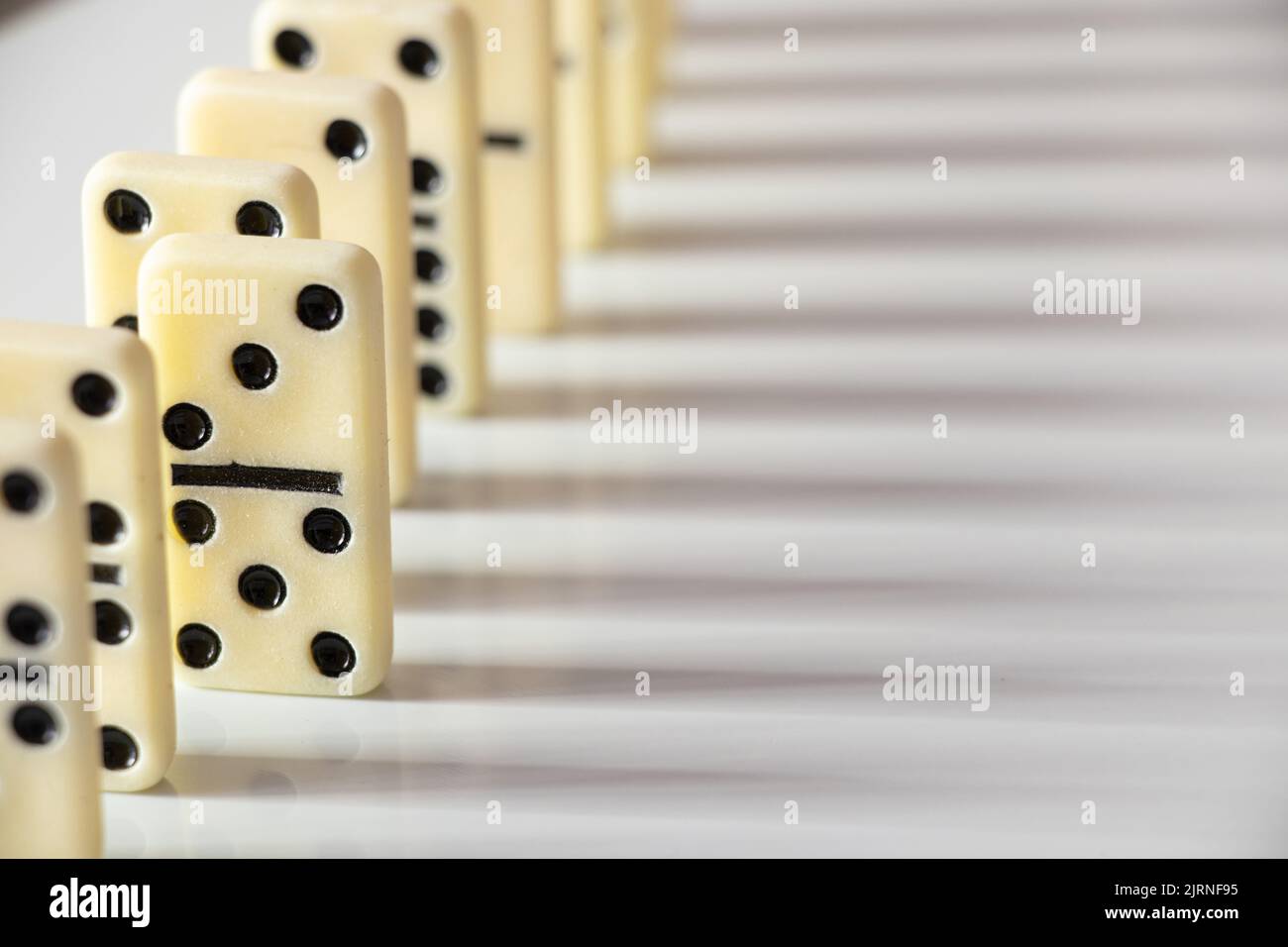 dominoes on a white background close-up, domino effect Stock Photo - Alamy
