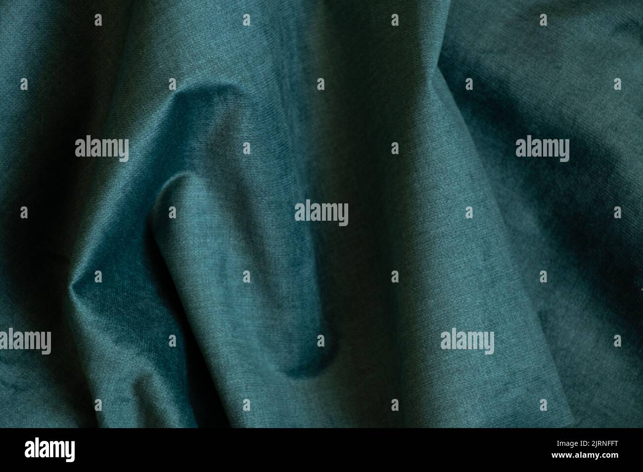 Dark green wrinkled fabric as a background close-up, fashion and trends ...