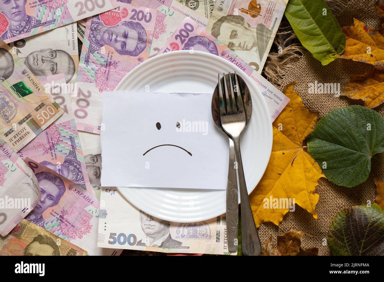 Ukrainian money lies on the table in autumn leaves and in a plate sad ...