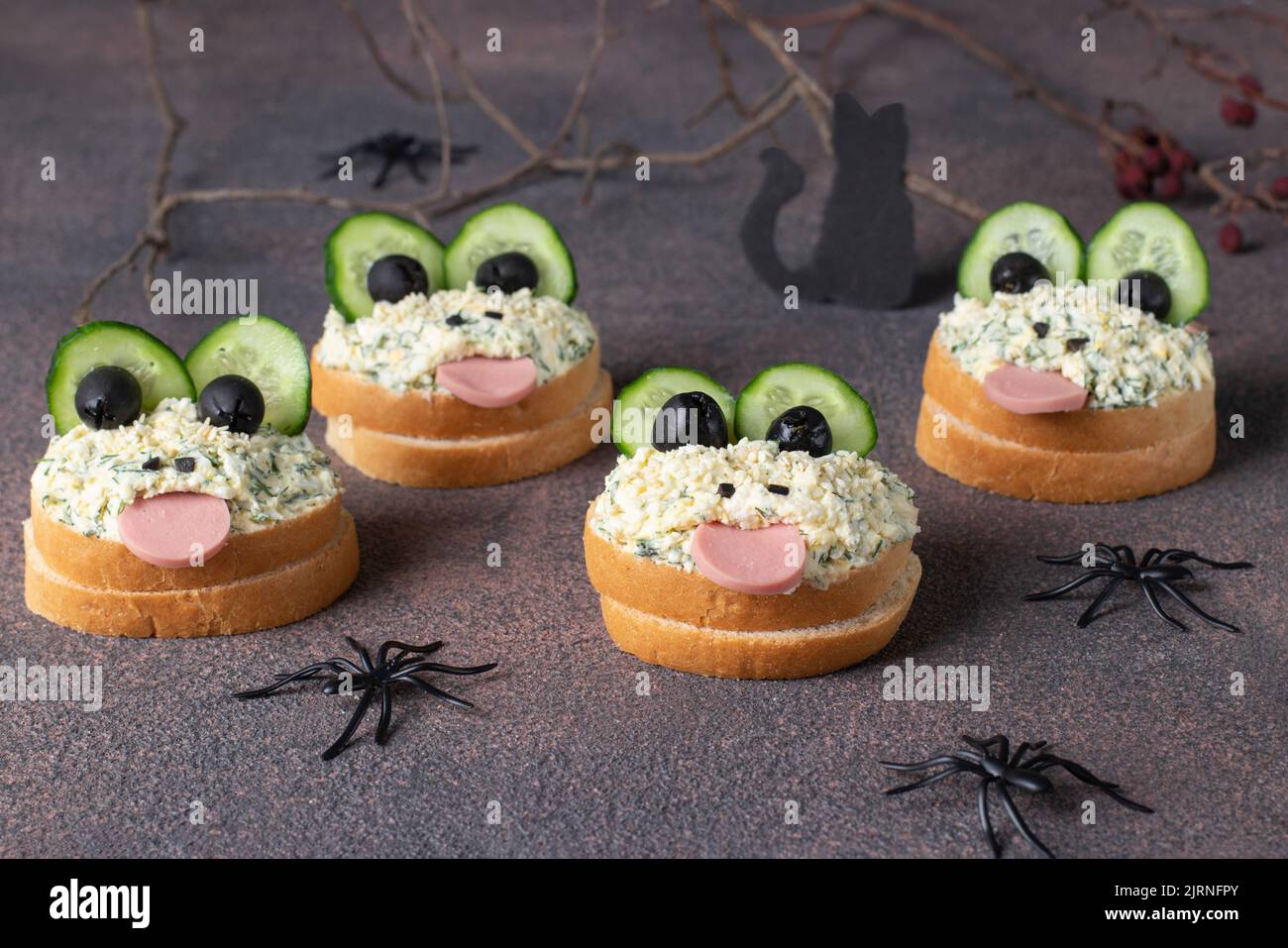 Sandwiches with cucumber, sausage, black olives, egg and melted cheese ...