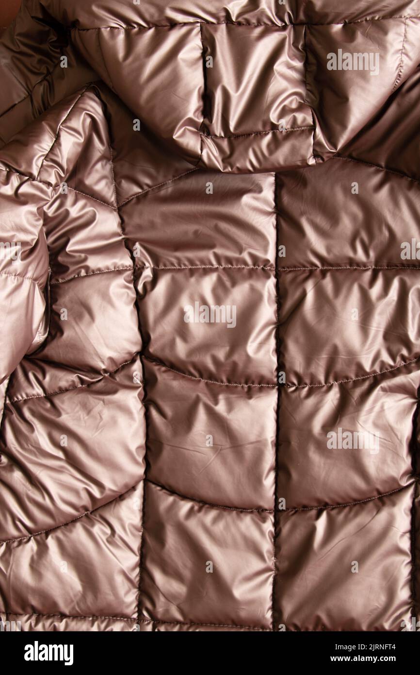 womens quilted bronze brown padded jacket as background, background of ...