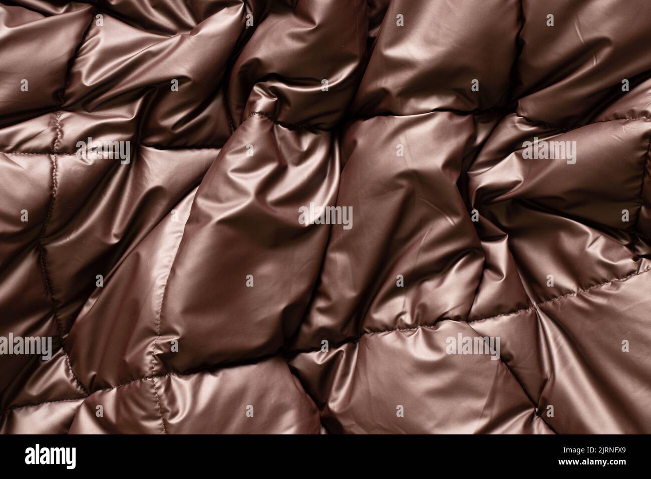 womens quilted bronze brown padded jacket as background, background of ...