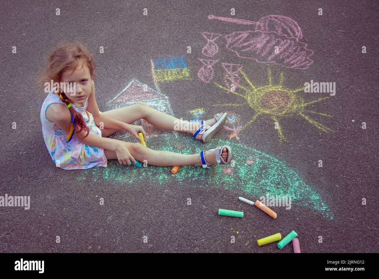 Ukrainian girl child draws children's drawings with chalk on the pavement Stock Photo - Alamy