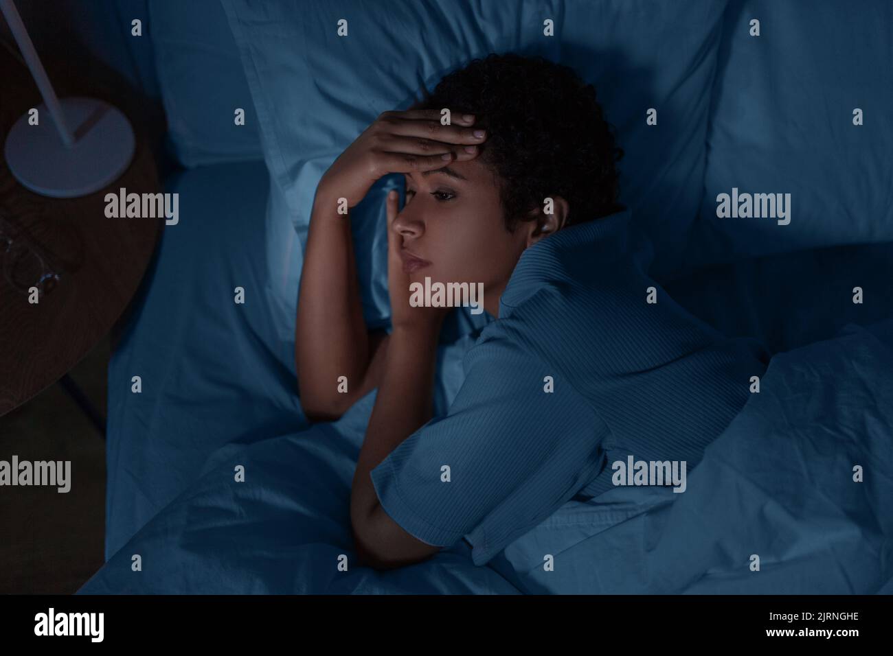 sleepless african woman lying in bed at night Stock Photo - Alamy