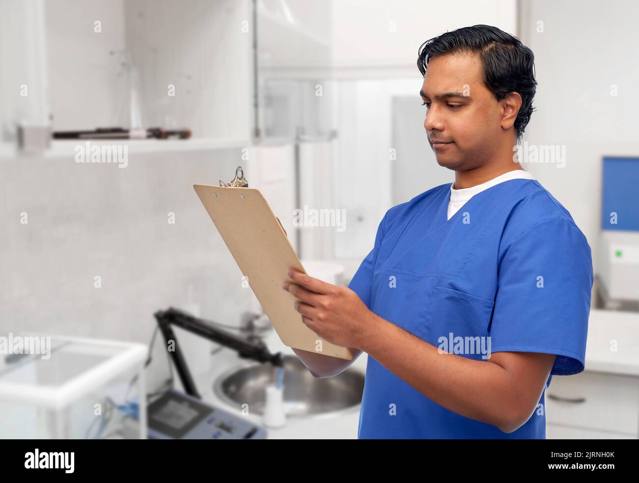 male doctor writing medical report on clipboard Stock Photo - Alamy