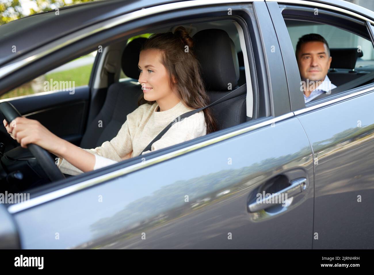 female driver driving car with male passenger Stock Photo - Alamy