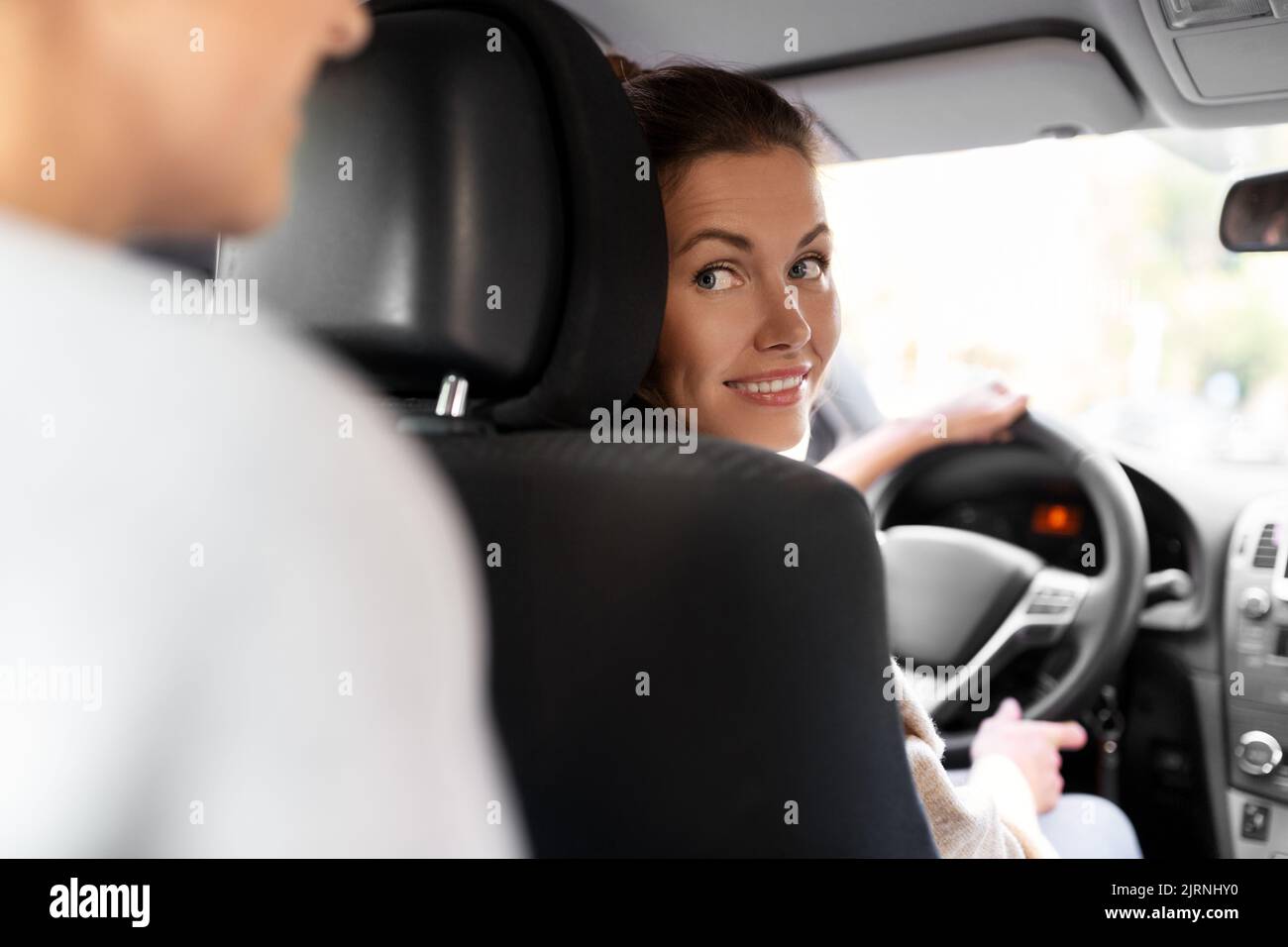 female driver driving car with passenger Stock Photo - Alamy