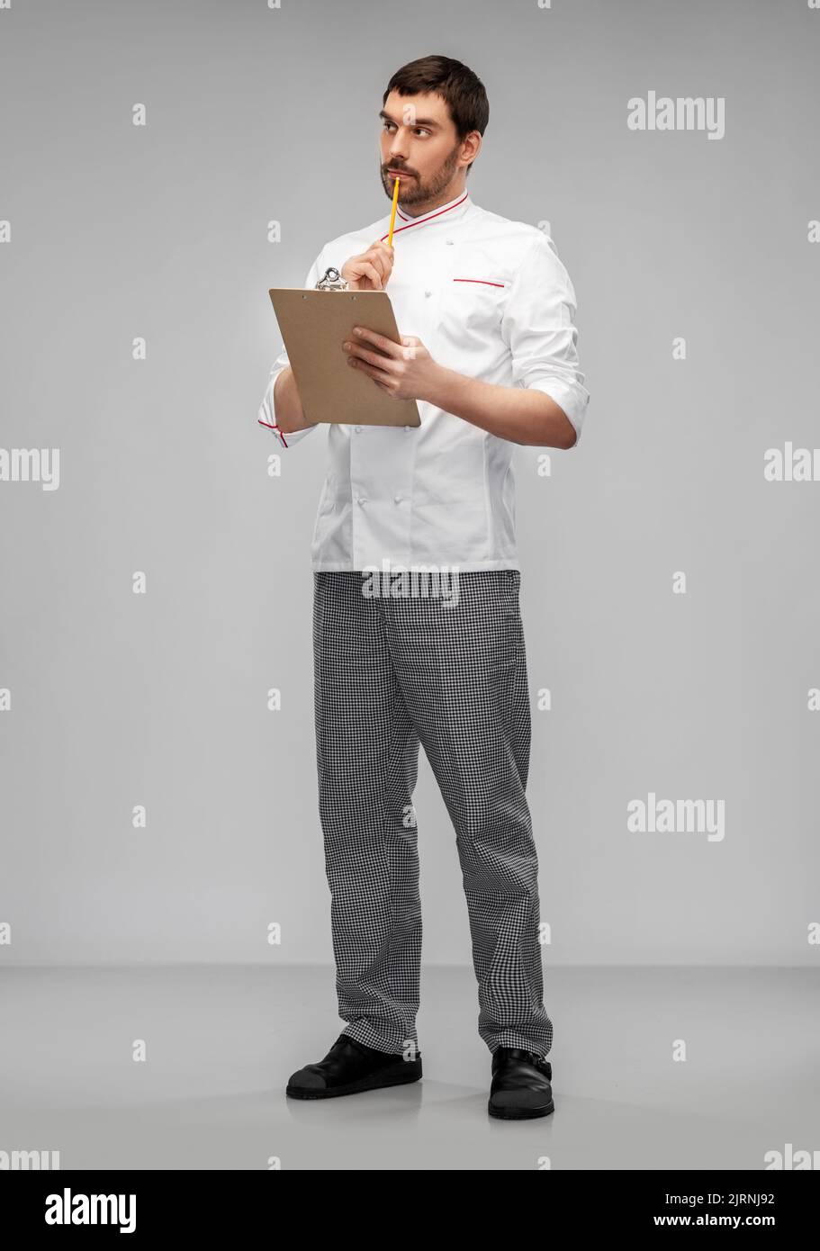 thinking male chef with clipboard and pencil Stock Photo - Alamy