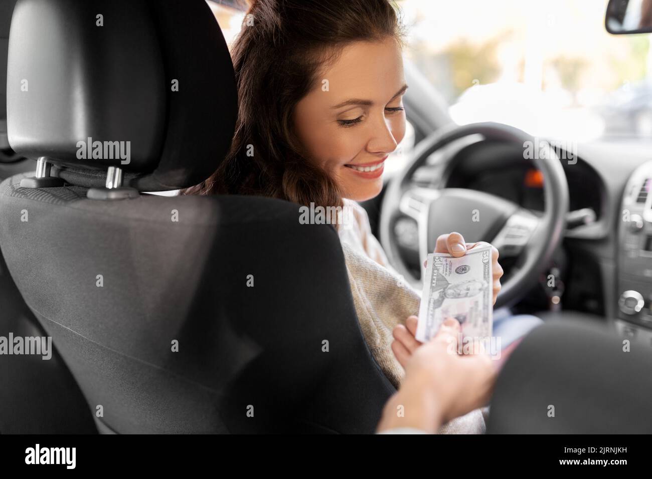 female car driver taking money from passenger Stock Photo - Alamy